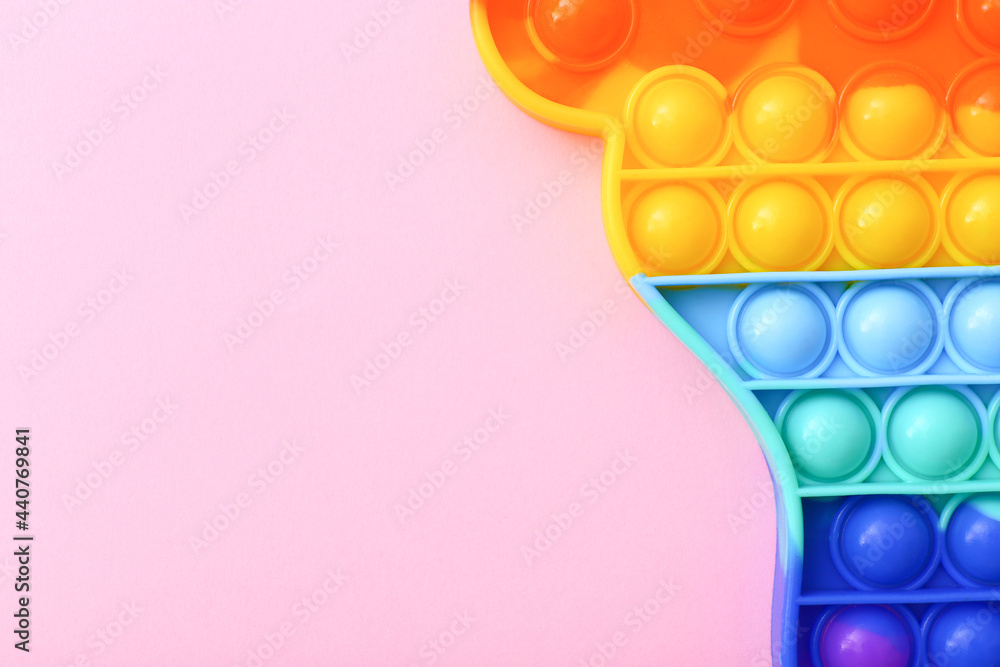 Colorful antistress sensory toy fidget push pop it on pink background ...