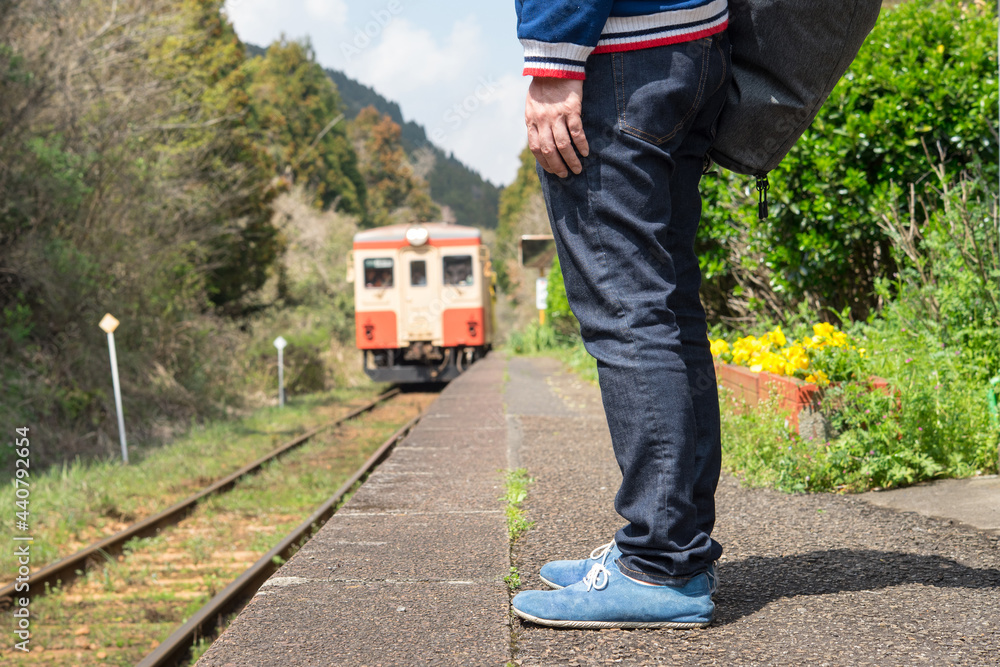 Train coming to rural railway station platform and passenger 田舎の駅のホームに ...