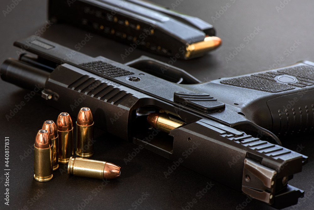 Semi automatic pistol with munitions and magazine on black base. Stock ...