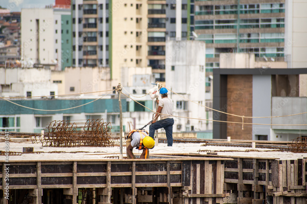 Construction workers on top of a construction site using safety ...