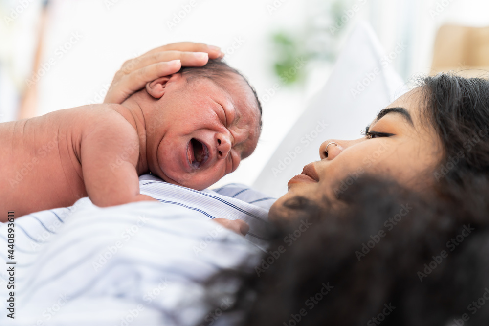Newborn baby crying on mother's. Mother take care her African American ...