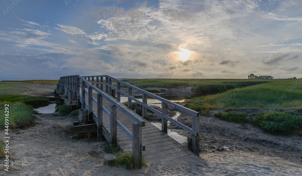 View of of salt marsh, mud flat and bridge over marsh channel in Sankt ...