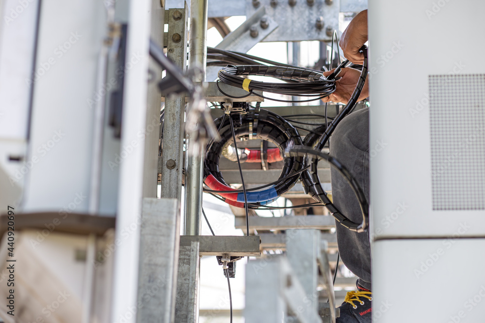 Installing a new mobile network cable behind the phone control cabinet ...