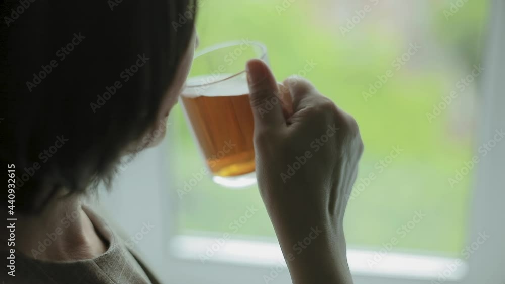 Video Stock Slow motion. The brunette stands at the window with her ...