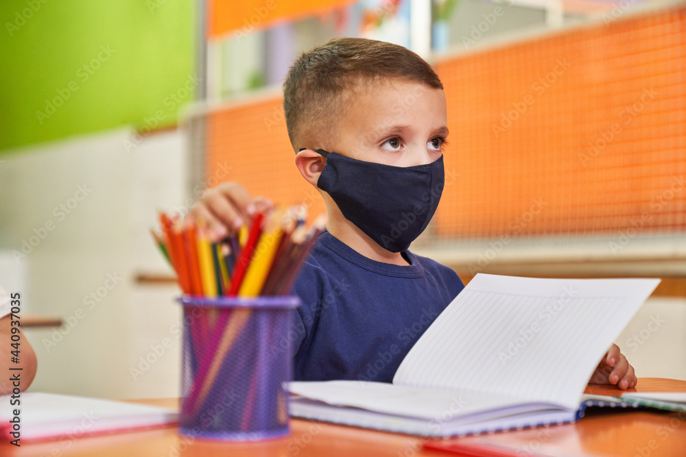Boy with mask because of Covid-19 as a student in class Stock Photo ...
