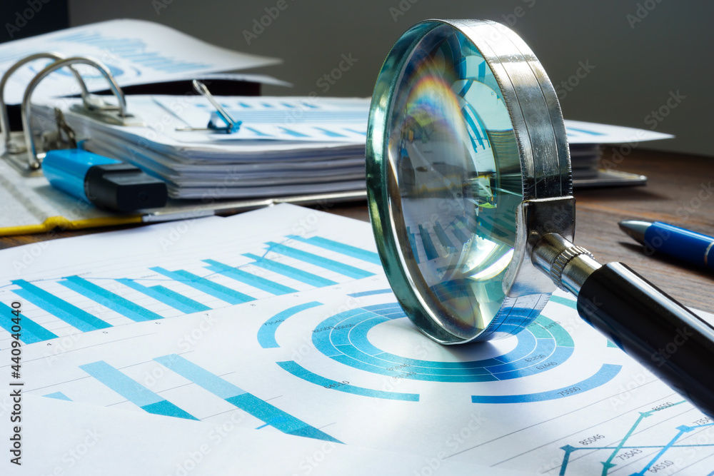 Magnifying glass as symbol of audit and papers. Stock Photo | Adobe Stock