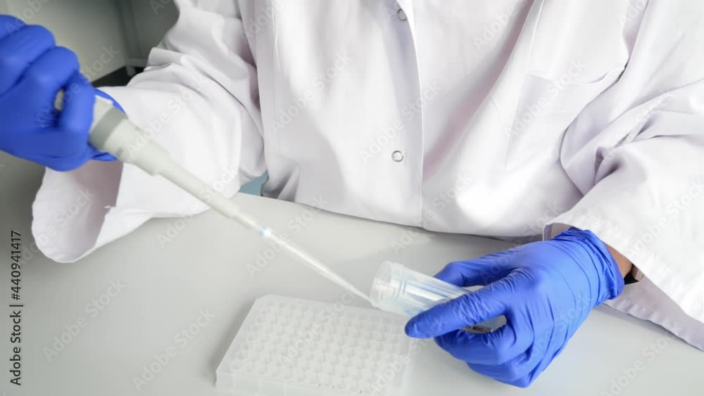 Laboratory researcher, scientist or nurse pipetting chemical reagents ...
