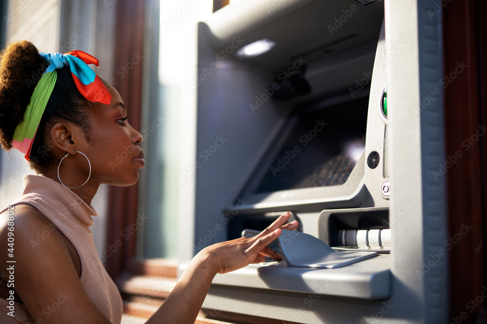 Beautiful african women using ATM machine. Attractive young woman ...