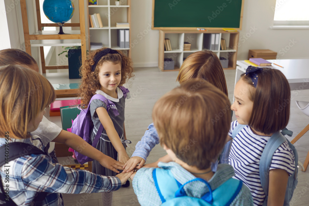 Team of school children joining hands standing in circle in modern ...