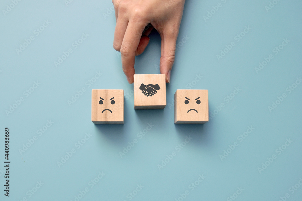 Foto de Wooden cubes with drawings of angry faces and a handshake ...
