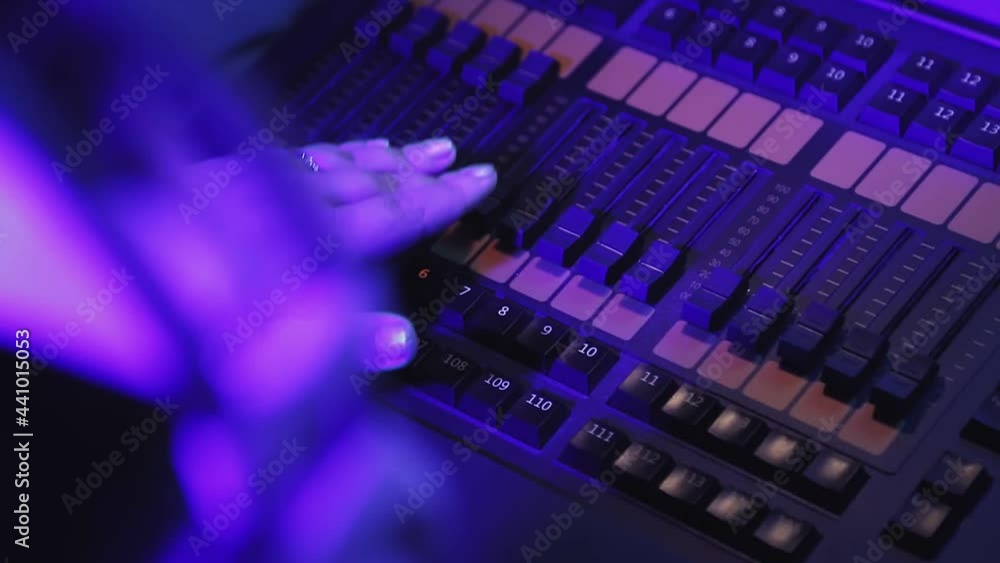 Hand A woman illuminator at the remote control in the lighting room ...