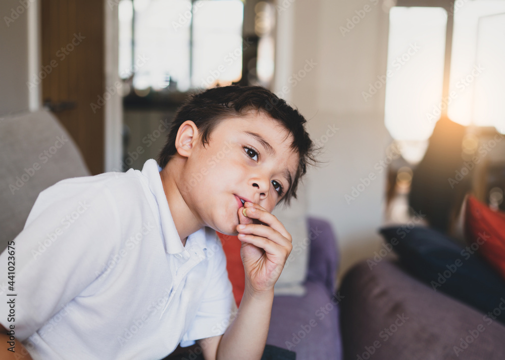 Emotional portrait young boy looking out deep in thought while eating ...