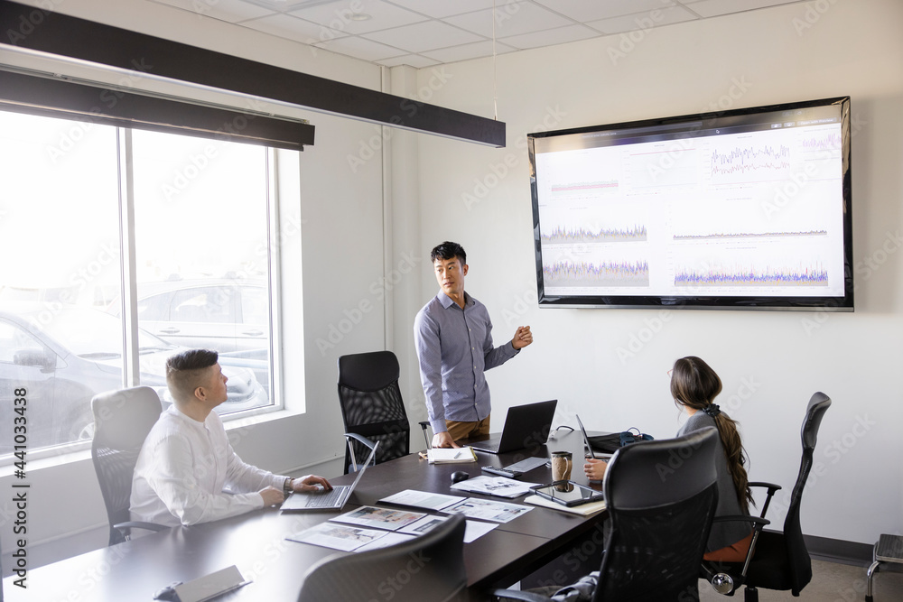 Business people discussing data on screen in conference room meeting ...