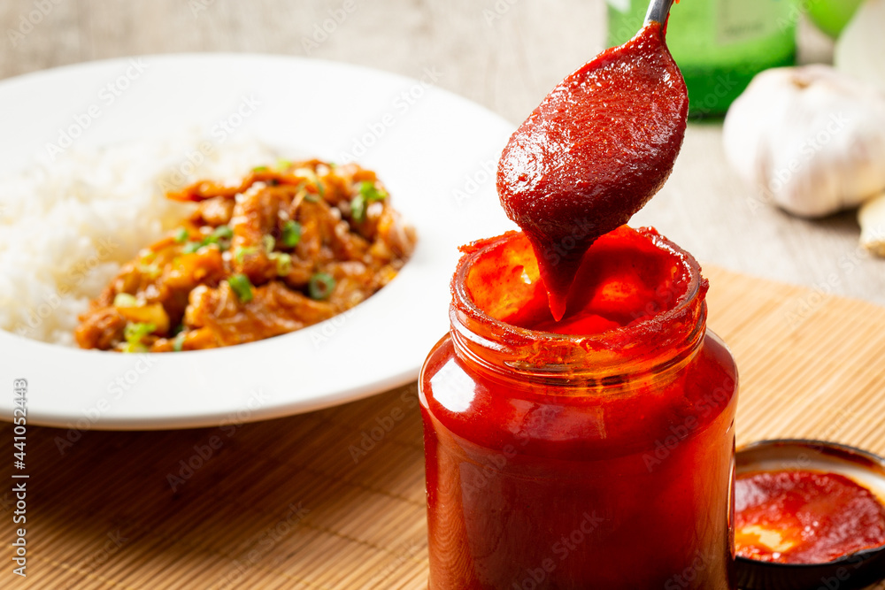 Gochujang (Korean spicy sauce) in jar and dipping by spoon Stock Photo ...