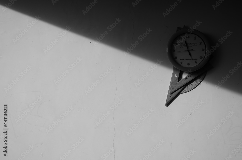 Wall clock hiding in the shadows Stock Photo | Adobe Stock