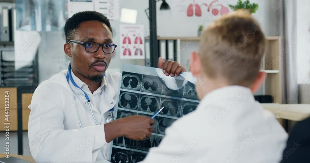 Handsome confident skillful black-skinned doctor in white gawn ...