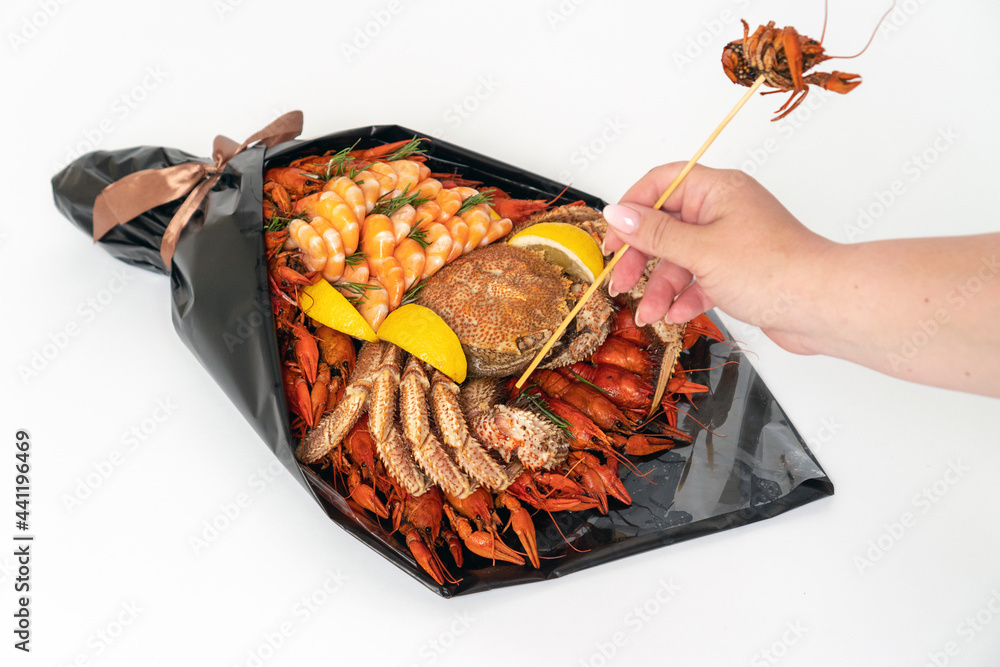 A female hand inserts a stick with cancer into a seafood bouquet ...