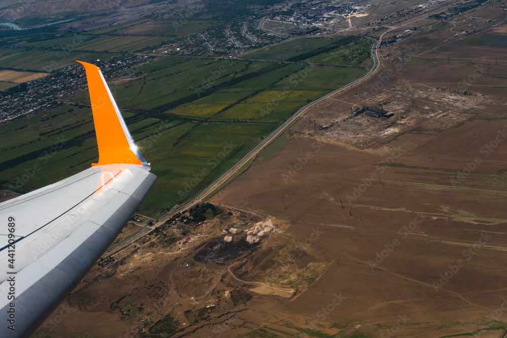 Flying and Traveling, Wing of an airplane flying above ground ...