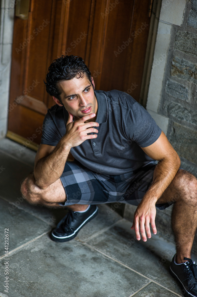 Dressing in a gray shirt, pattern shorts and black leather sneakers ...