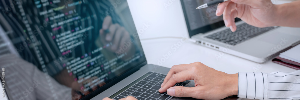 programmer writing program code with two monitors and working on a new software or hacker ...