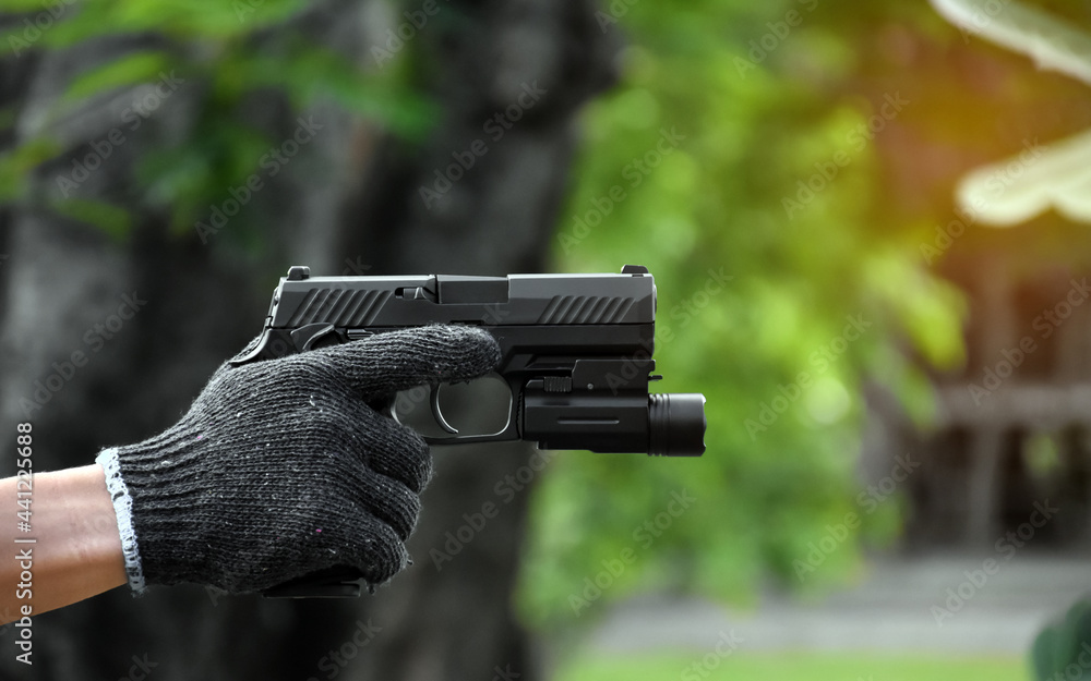 Automatic black 9mm pistol in hands ready to pull the trigger aiming to ...