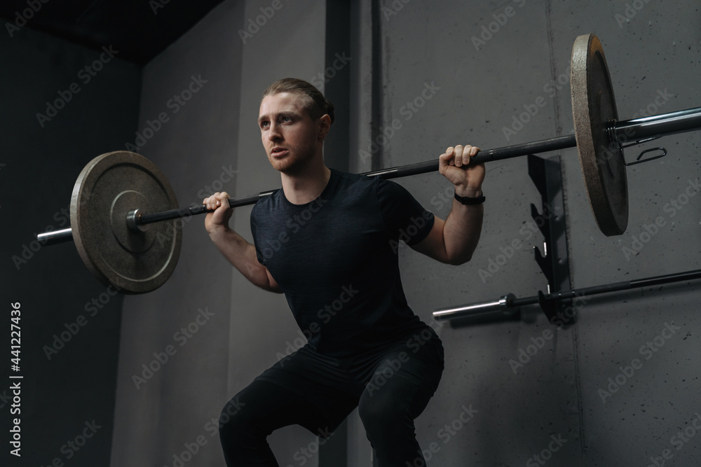 Strong crossfit athlete having workout and bodybuilding with barbells ...