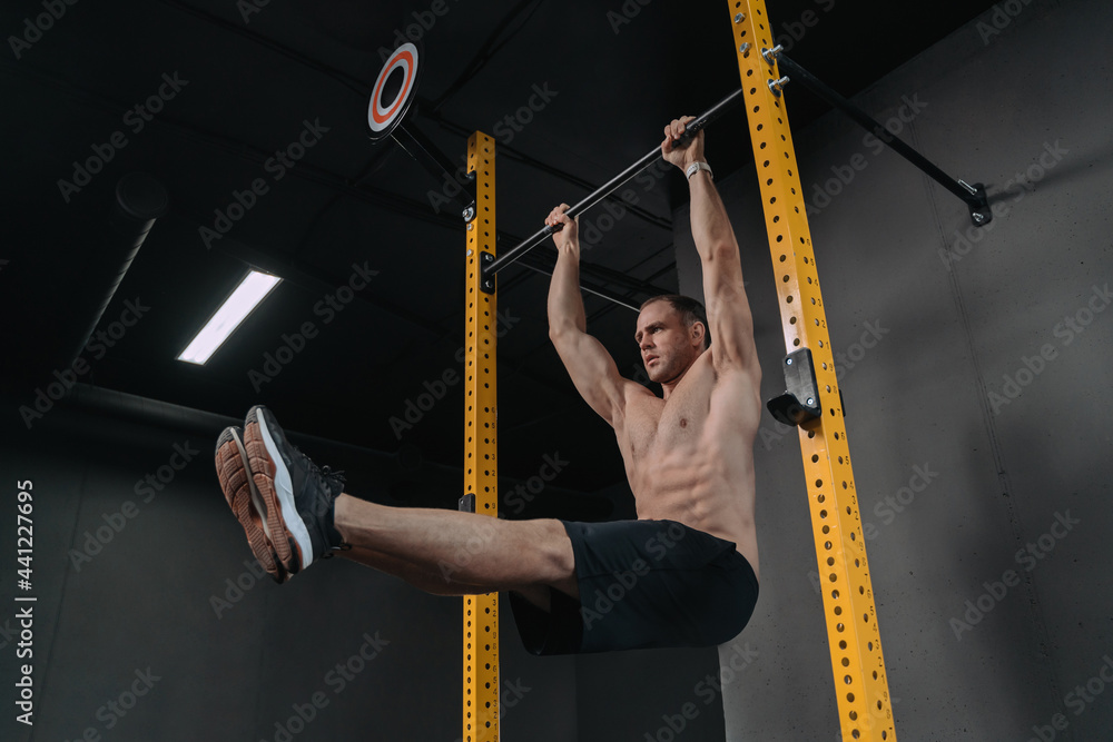 Foto de Muscular brutal shirtless crossfit athlete doing abs exercises ...