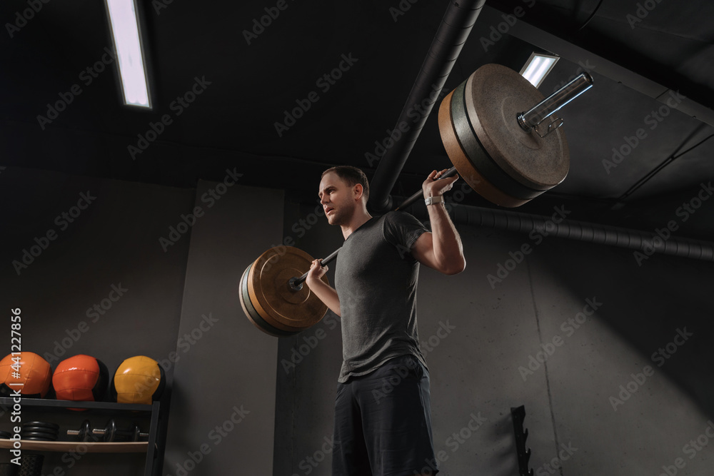 Fitness man doing weight training with barbell. Young muscular athlete ...