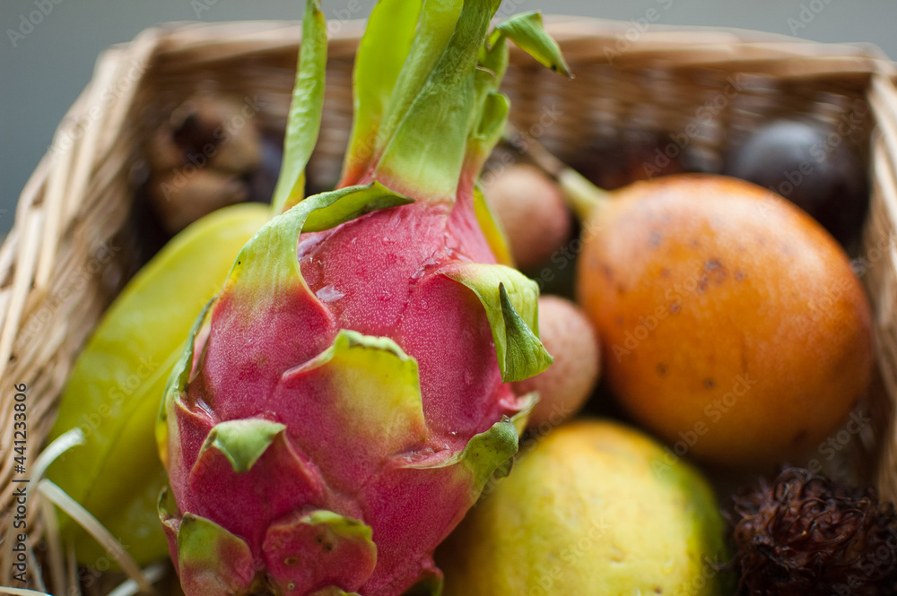 Big basket of fresh tropical fruits, passion fruit, carambola, dragon ...