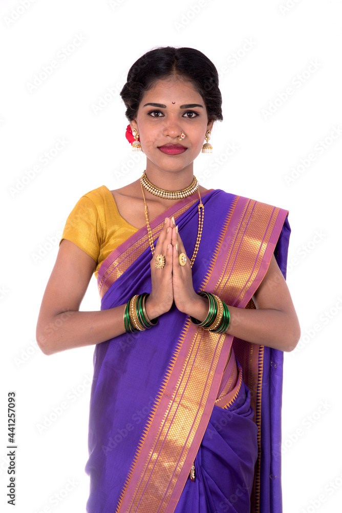 Young Indian girl in traditional clothing greeting namaste, Welcome ...