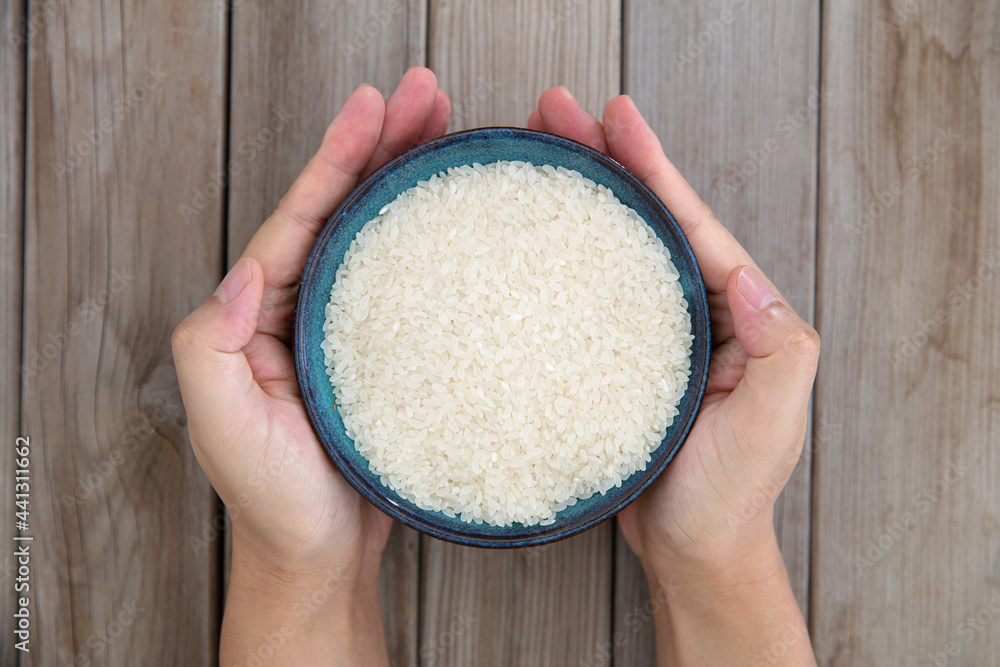 Hand holding a bowl of rice grain Stock Photo | Adobe Stock