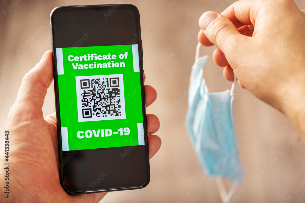 A man holds electronic certificate of vaccination covid 19 and a ...