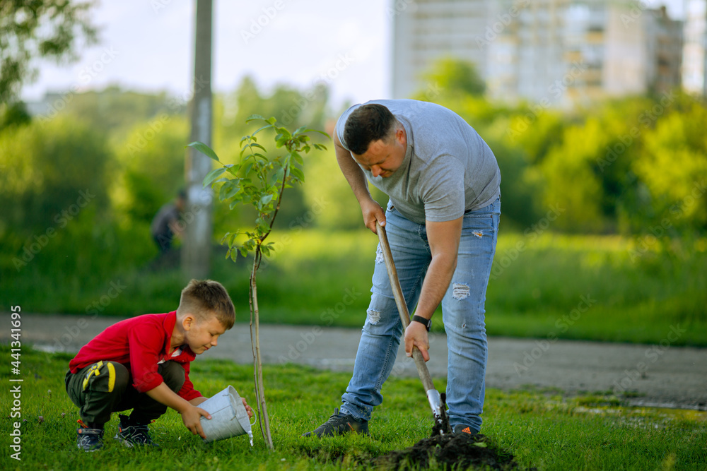 father and son planting tree father holding the shovel and son holding ...
