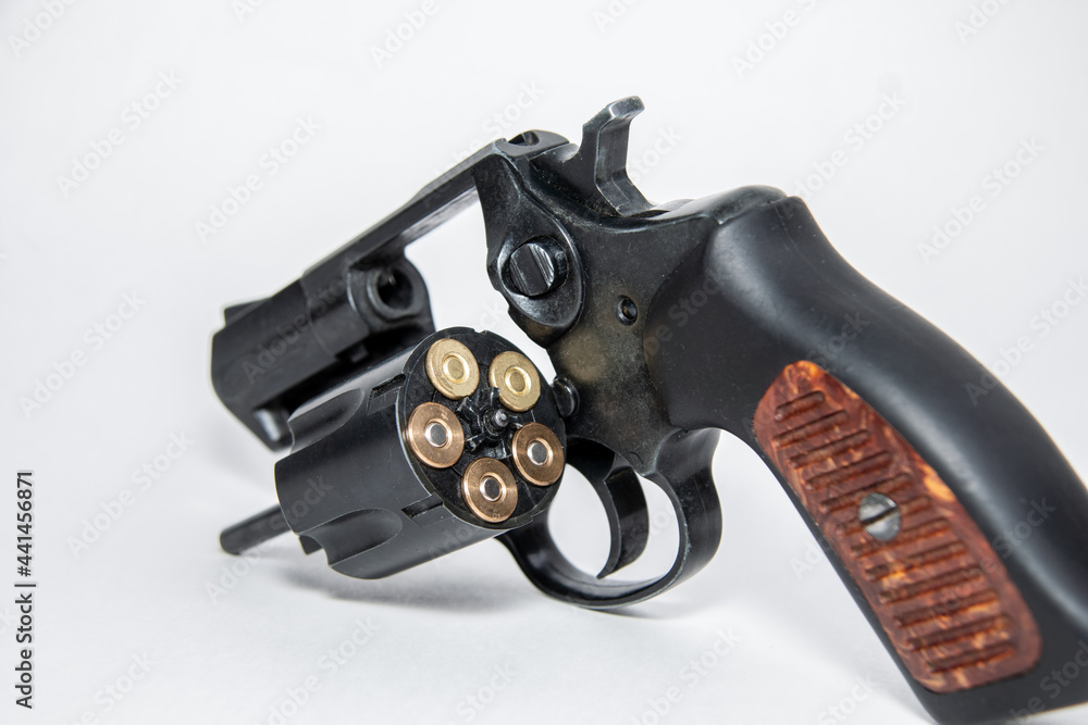 Revolver with a full drum of cartridges on a white background. Close-up ...