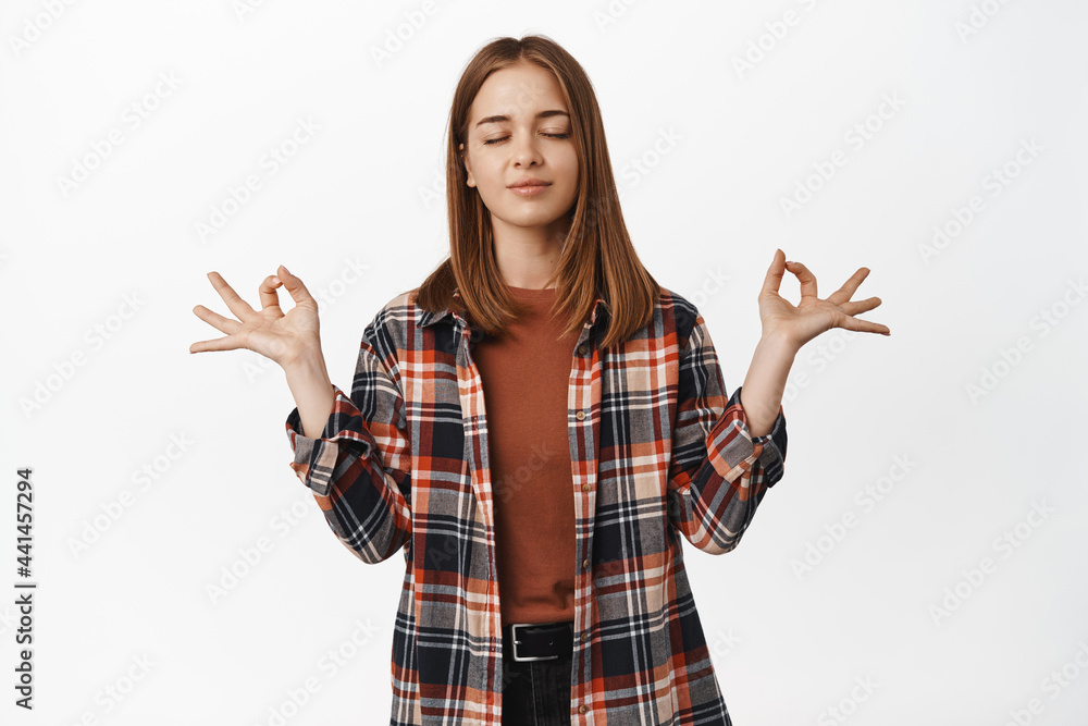 Staying calm. Young girl student close eyes, meditating, peace yoga gesture, holding hands in ...
