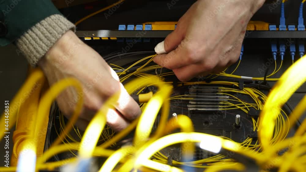 Worker connects optical line internet wire in connection box. Service ...