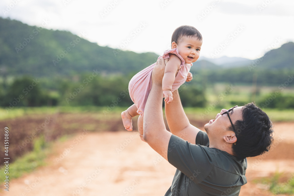 Father raises his daughter is not yet a year old lift up in the sky ...