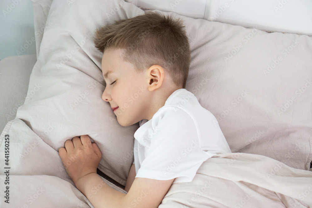 Cute little boy sleeping in bed at home. bed linen made of natural ...