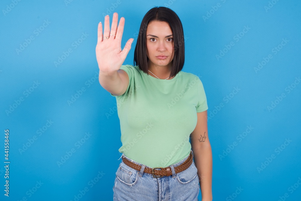 young beautiful brunette girl with short hair standing against blue ...