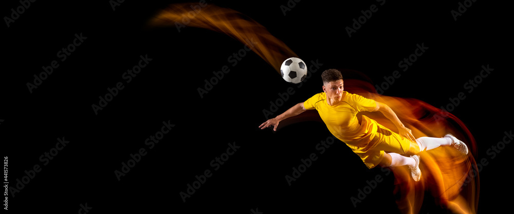 Flyer. One caucasian male football or soccer player training with ball ...