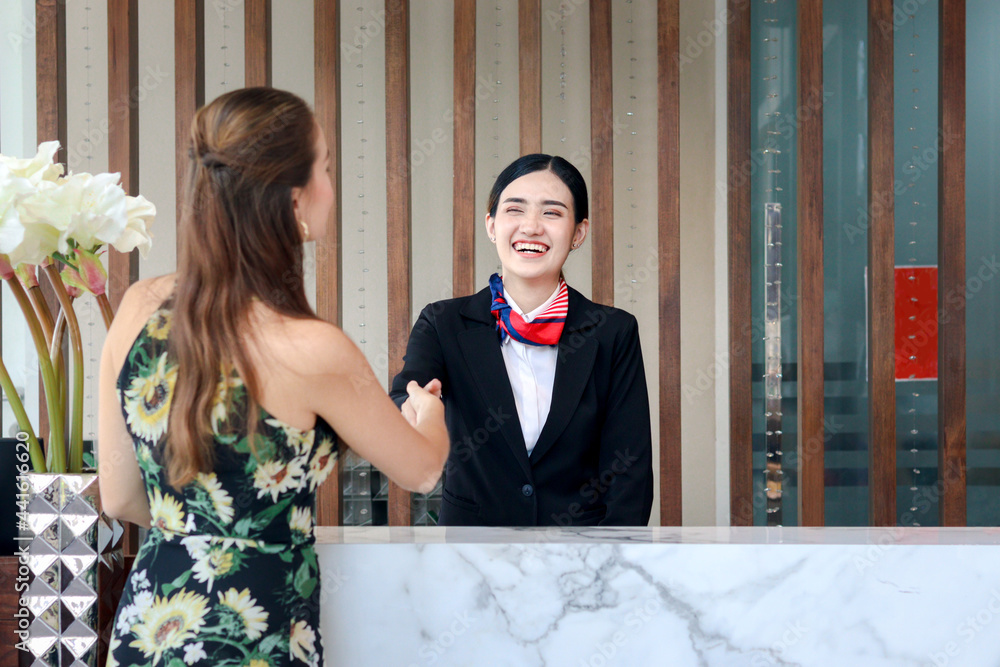 Happy smiling young beautiful Asian female receptionist in suit shaking ...