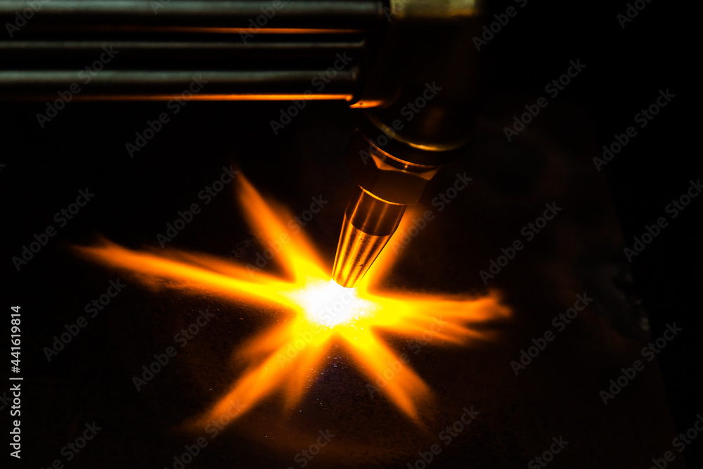 Gas cutting of metal. Gas cutter with copper nozzle with a stream of ...