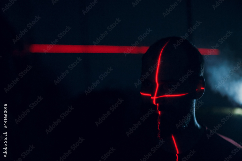 Man in dark with face illuminated scanning red laser on contour. Stock ...