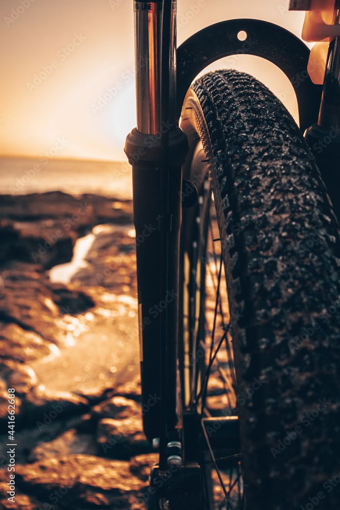 Detalle Bicicleta en la playa, con fondo de amanecer / close up Bicycle on the beach, with ...