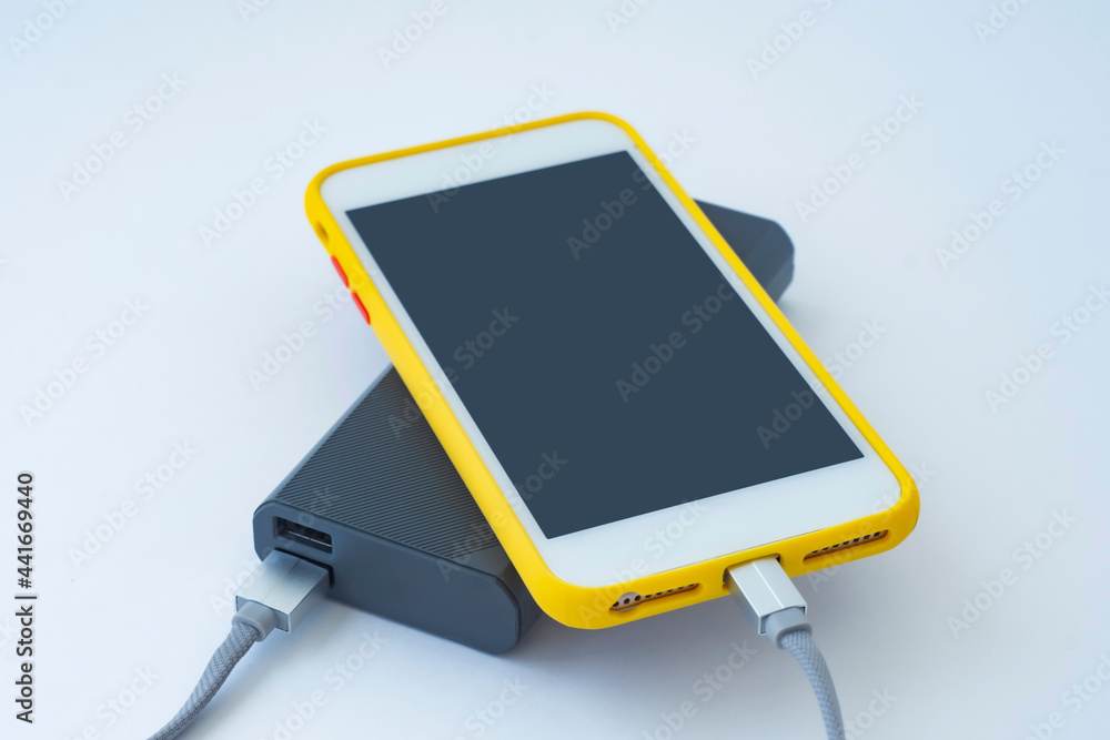 Portable charger charges a smartphone isolated on a white background ...