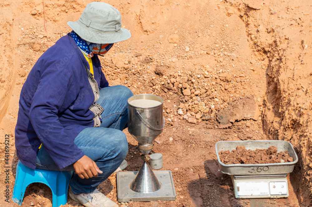 Worker using equipment for testing laboratory field density test sand ... Worker using equipment for testing laboratory field density test sand ...