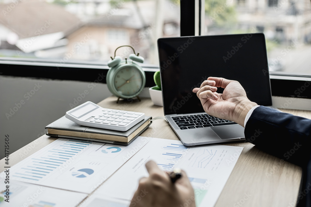Man pointing at laptop screen and documents lying on the table ...