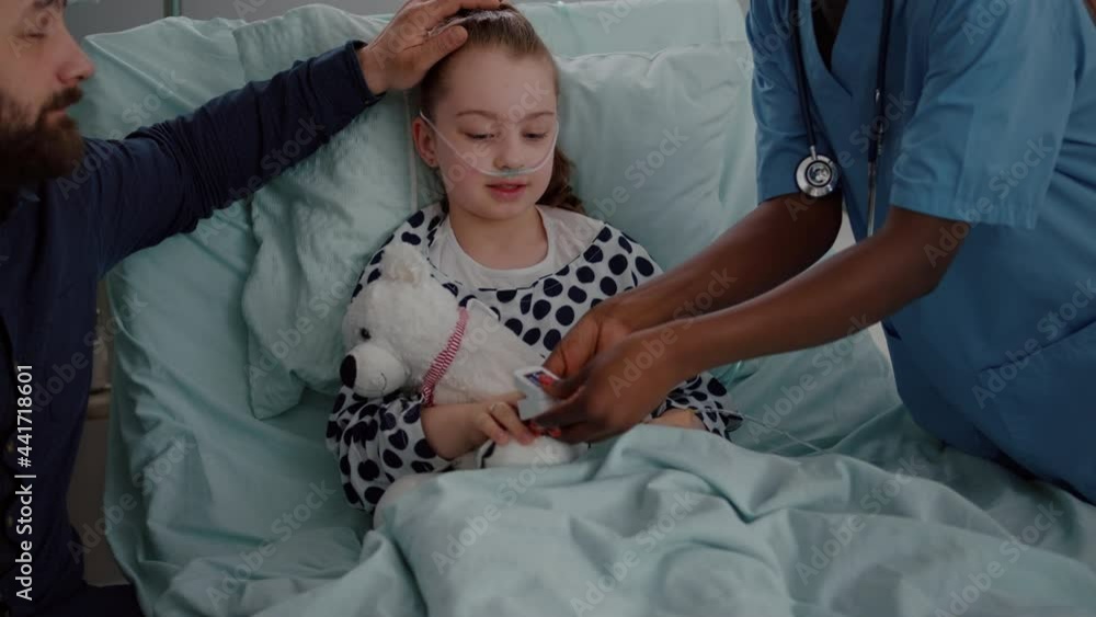 Worried father sitting with hospitalized sick daughter during medical ...
