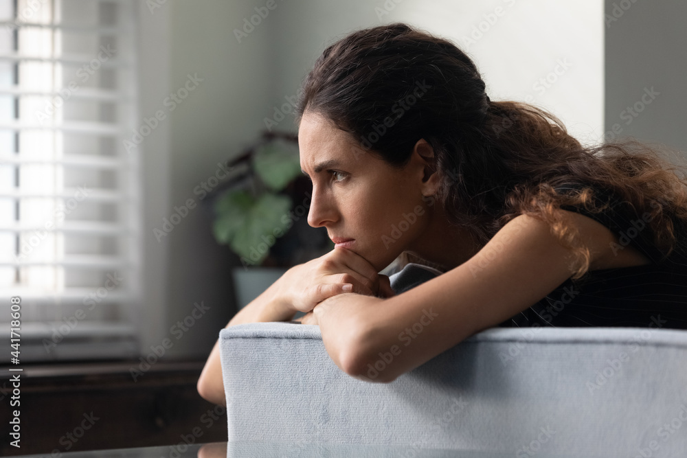 Sad young woman sit at home look in distance thinking pondering of life ...