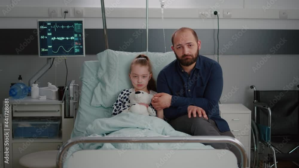 Portrait of sad father holding sick child hands looking into camera ...